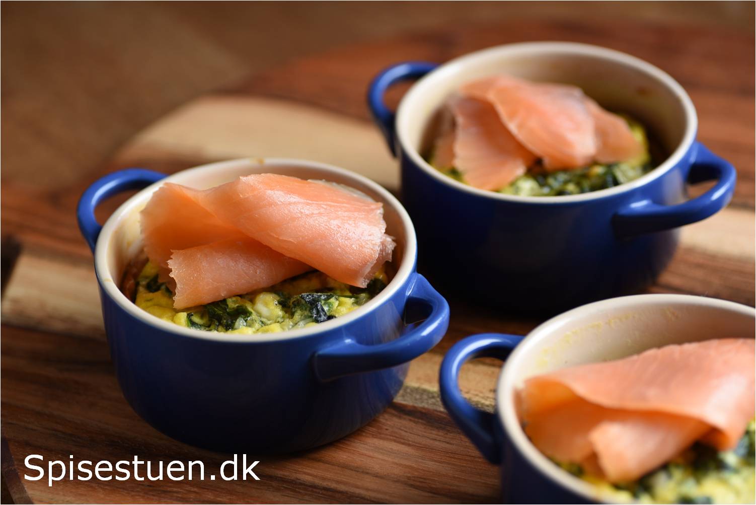 Små spinattærter med røget laks på toppen